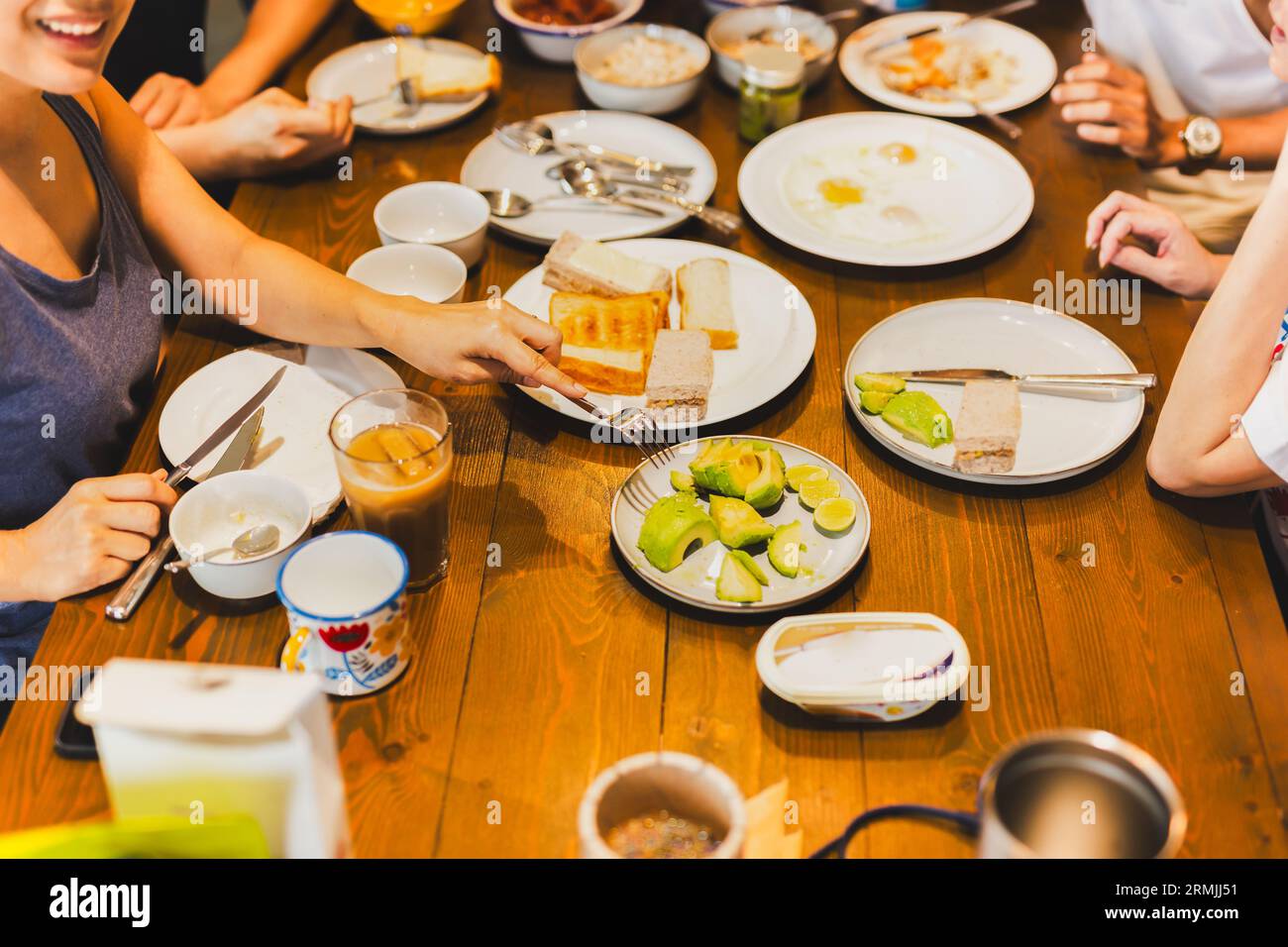Woman hands holding fork eating an avocado breakfast with friends Stock ...