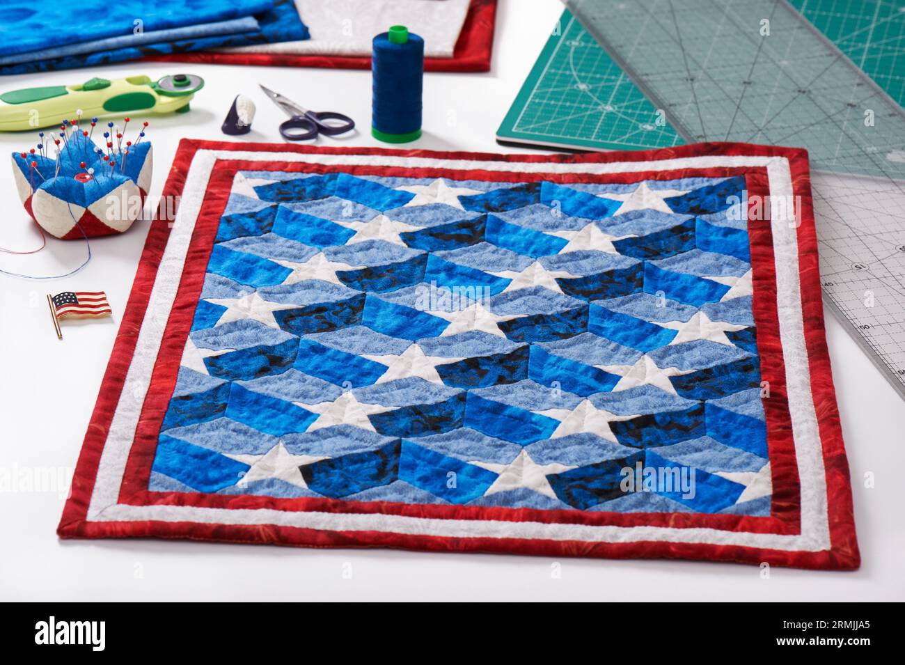 Completed quilt with stylized elements of American flag, patchwork tools Stock Photo - Alamy