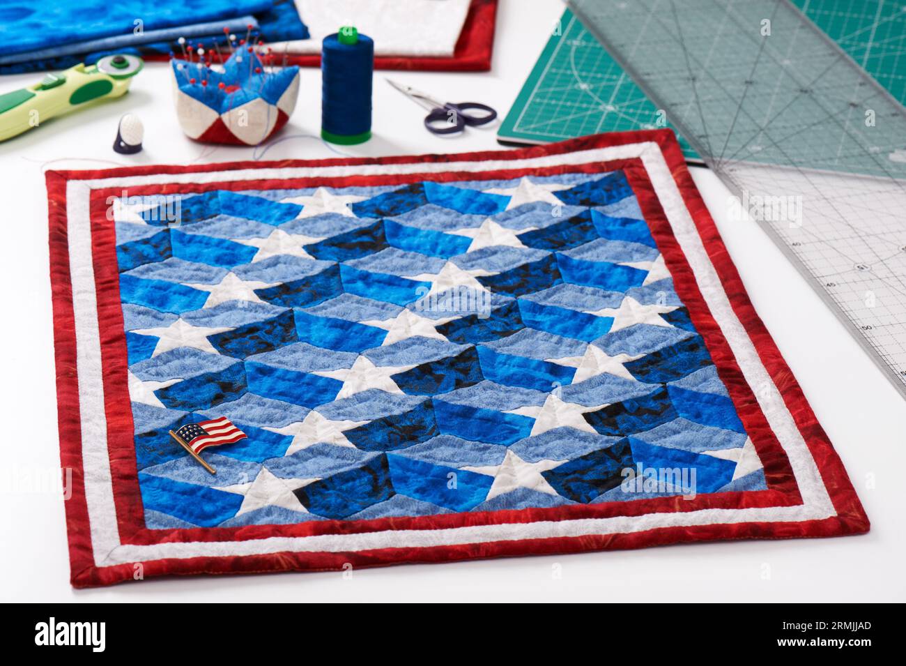 Completed quilt with stylized elements of American flag, patchwork tools Stock Photo - Alamy
