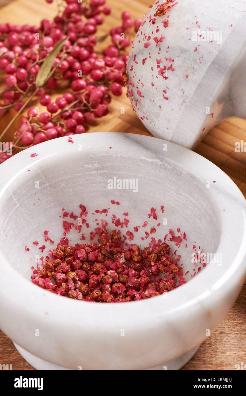 Dry rose pepper in white marble mortar next pestle Stock Photo - Alamy