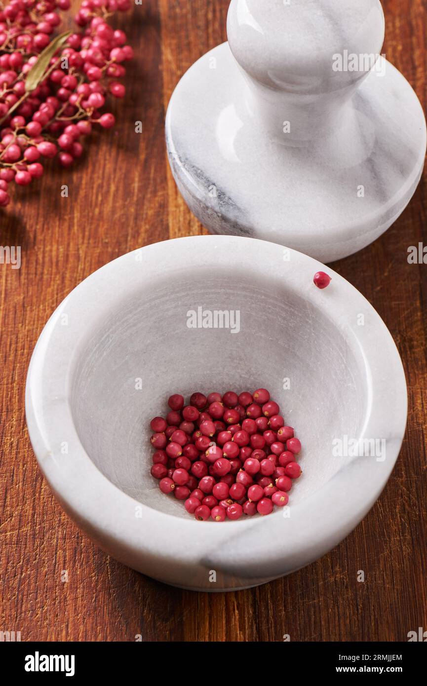 Dry rose pepper in white marble mortar next pestle Stock Photo - Alamy