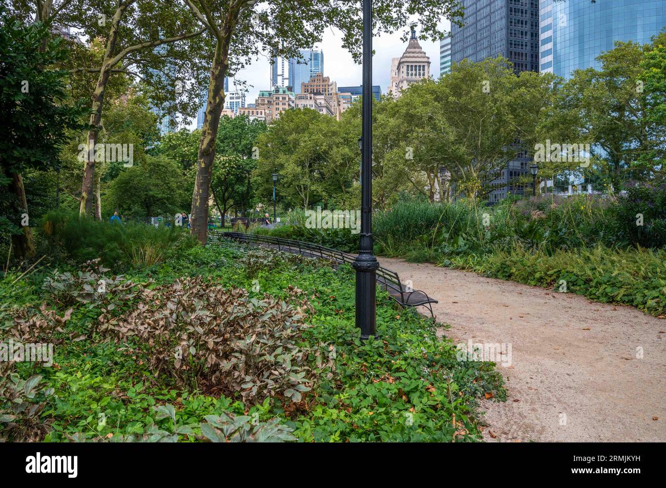 City park footpath through garden empty benches urban background Stock ...