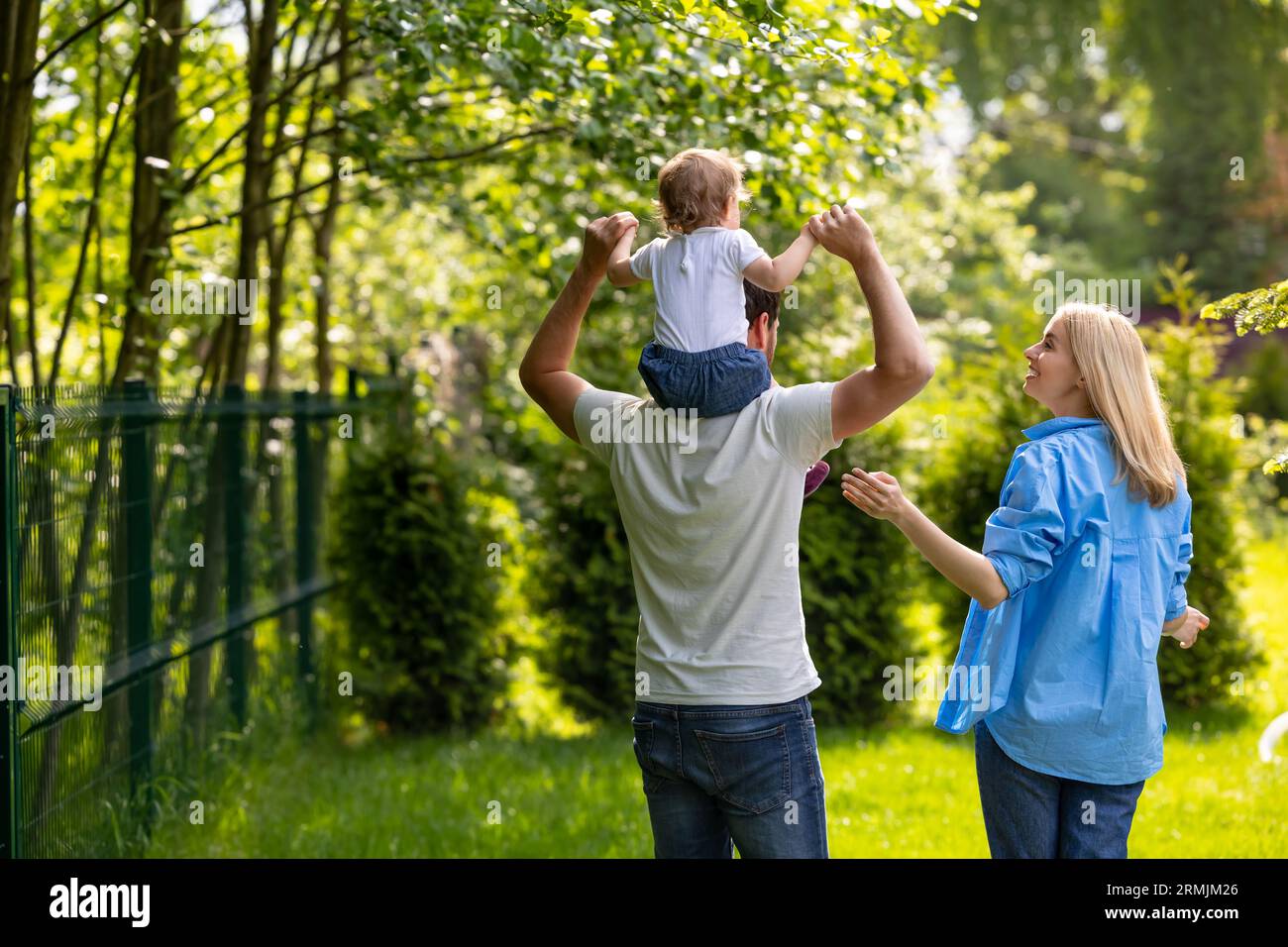 Happy parents spending time together with their kid outdoors Stock ...