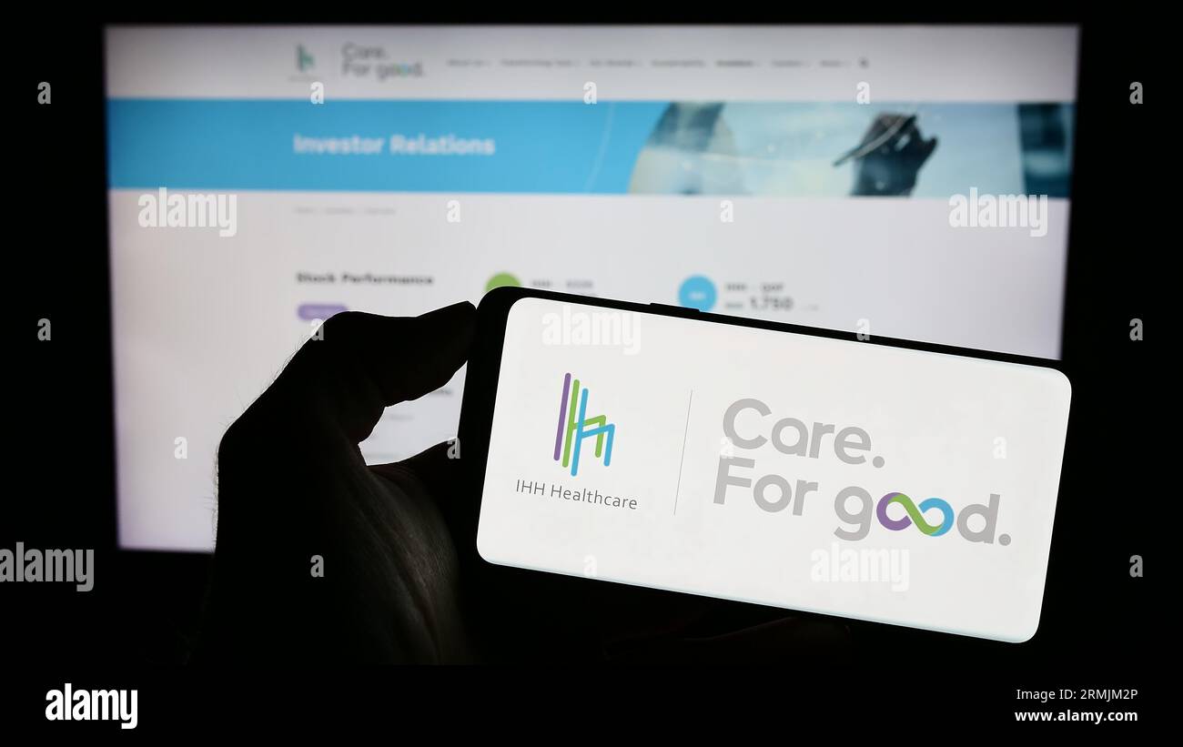 Person holding mobile phone with logo of Malaysian health company IHH ...