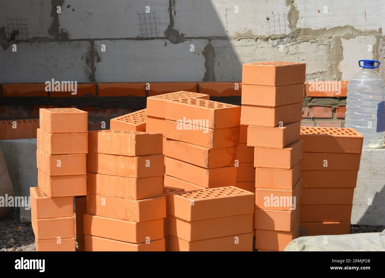 Pile of clay bricks and bottle with plasticizers for concrete ...
