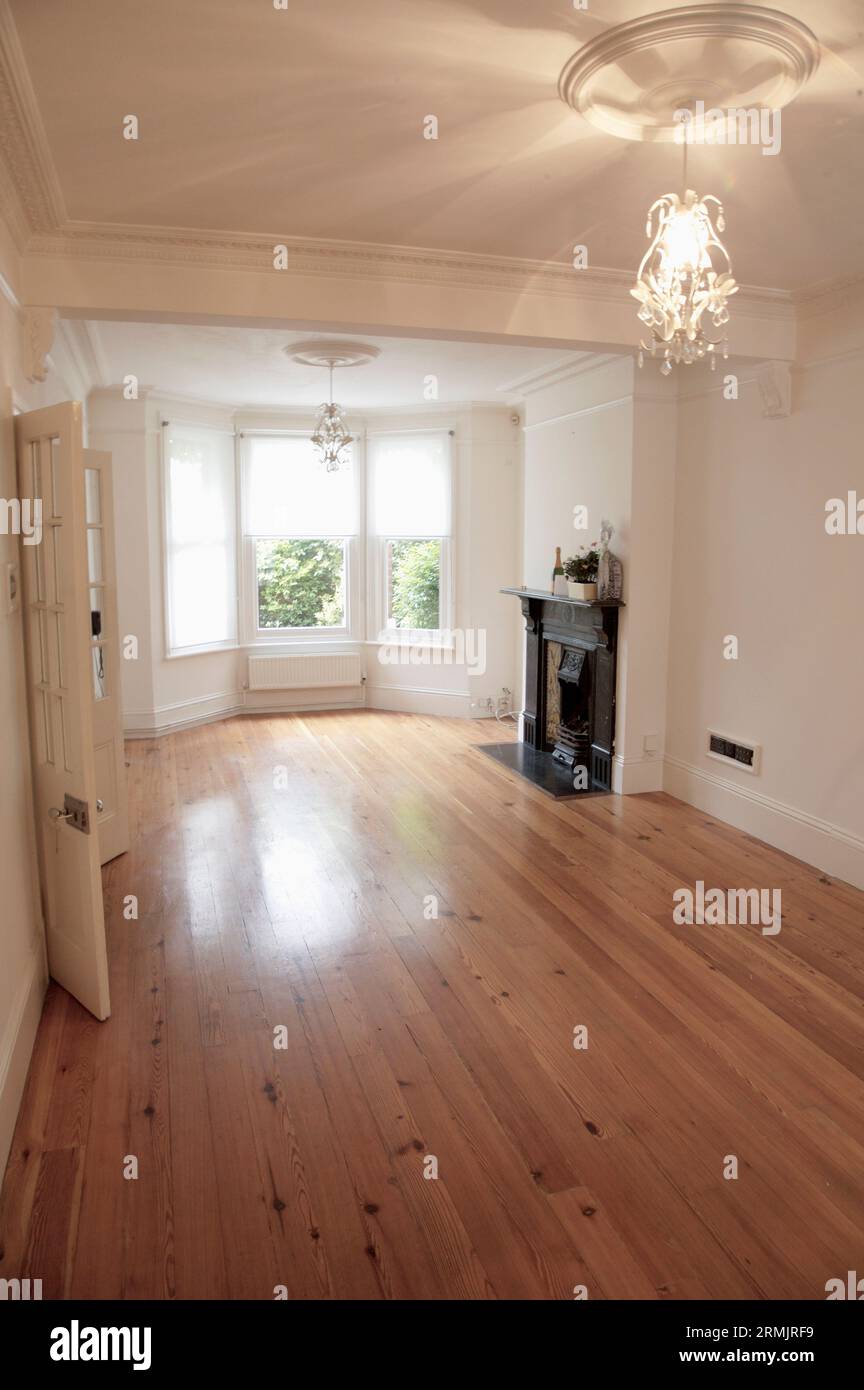 Empty room with fireplace and bay window Stock Photo - Alamy