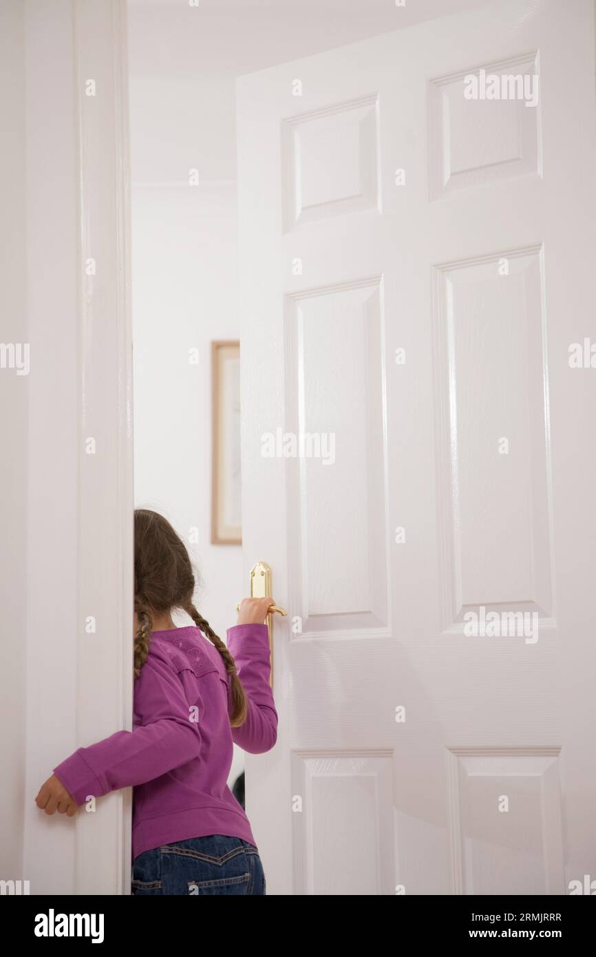 Back view of girl opening door Stock Photo - Alamy