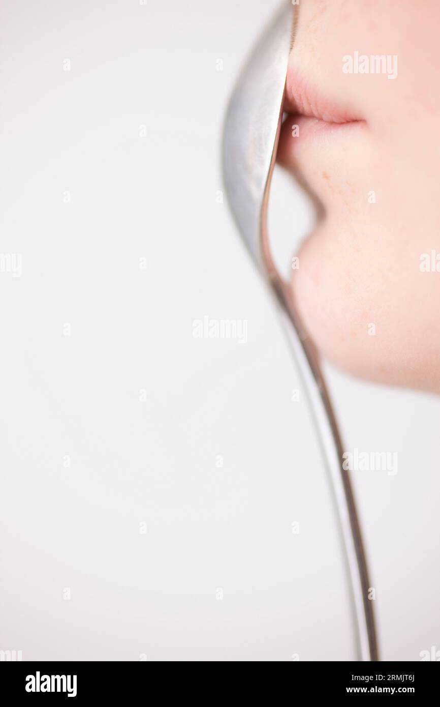 Woman Holding Spoon in front of Mouth Stock Photo - Alamy