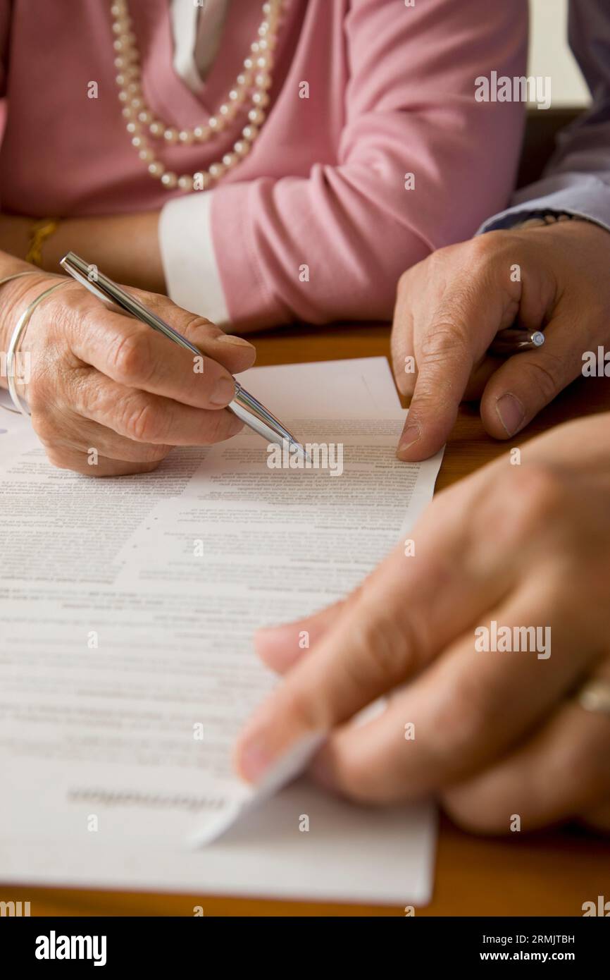 Close up of man and woman hands signing documents Stock Photo - Alamy