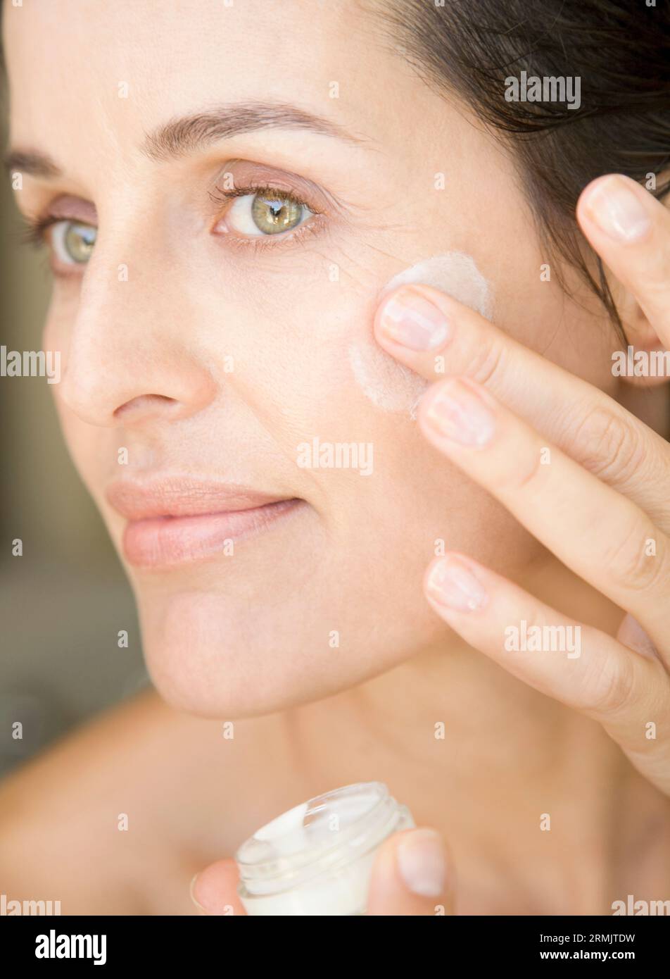 Woman applying moisturizing cream hi-res stock photography and images ...