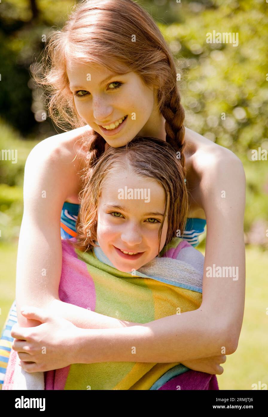 Teen girl hugging sister and drying her off Stock Photo - Alamy