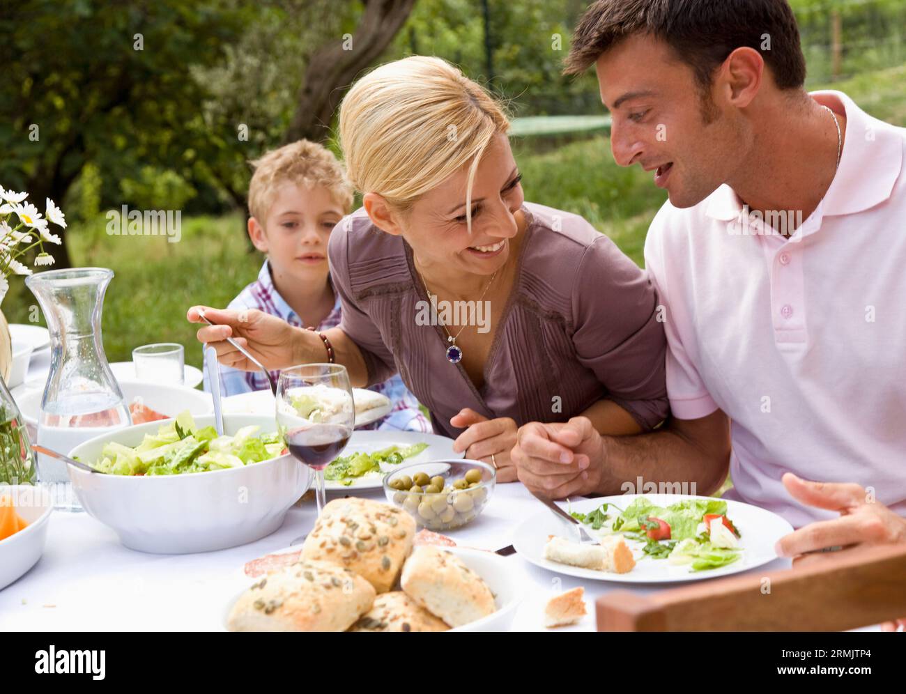 Couple and young boy having lunch outside Stock Photo - Alamy