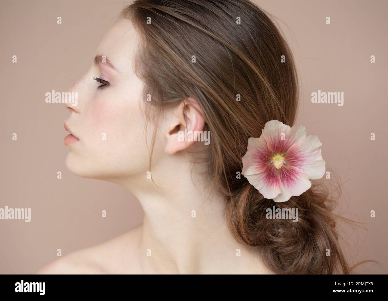 Profile of beautiful young woman with flower holding hair back Stock ...