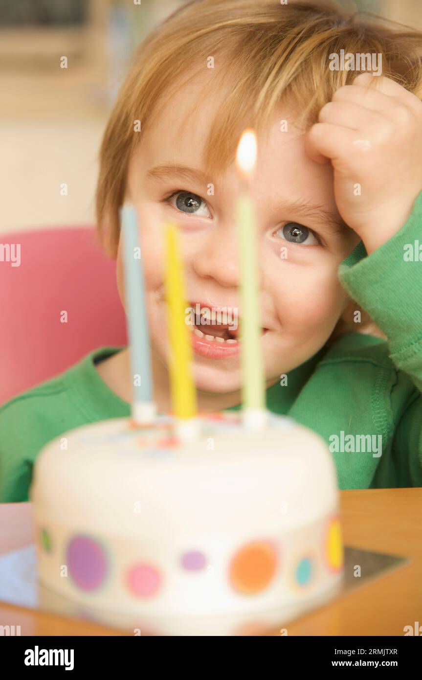 Toddler and birthday cake with three candles Stock Photo - Alamy