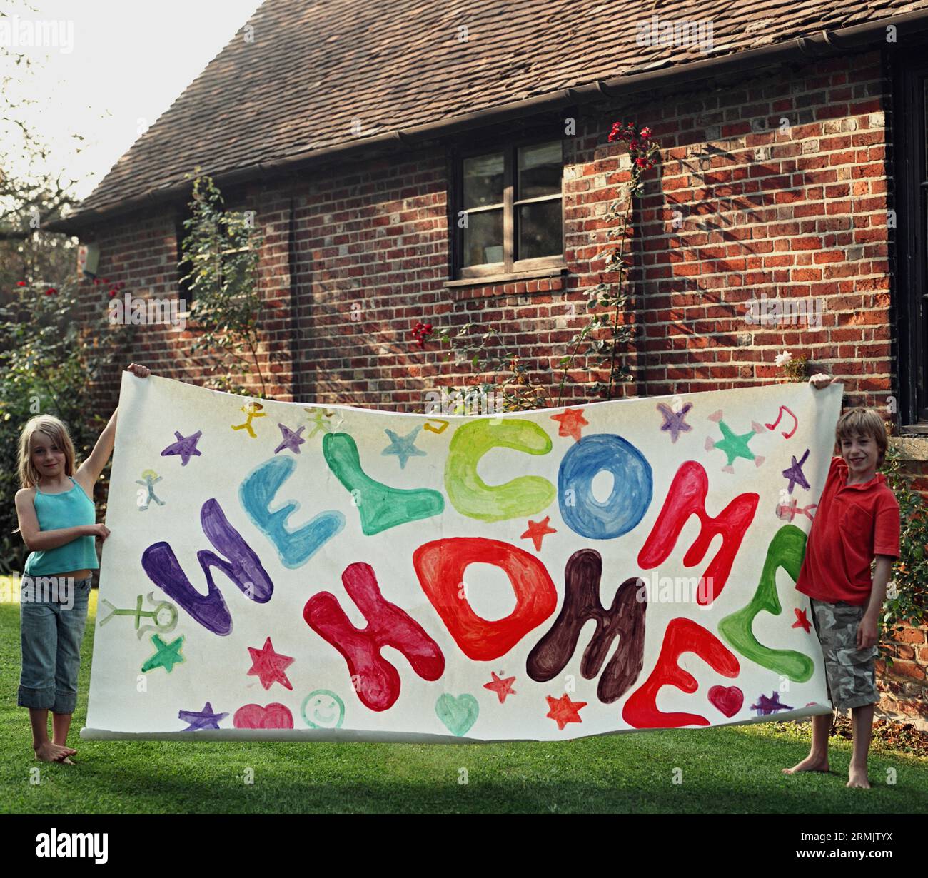 Portrait of two young children holding colorful welcome home sign Stock ...