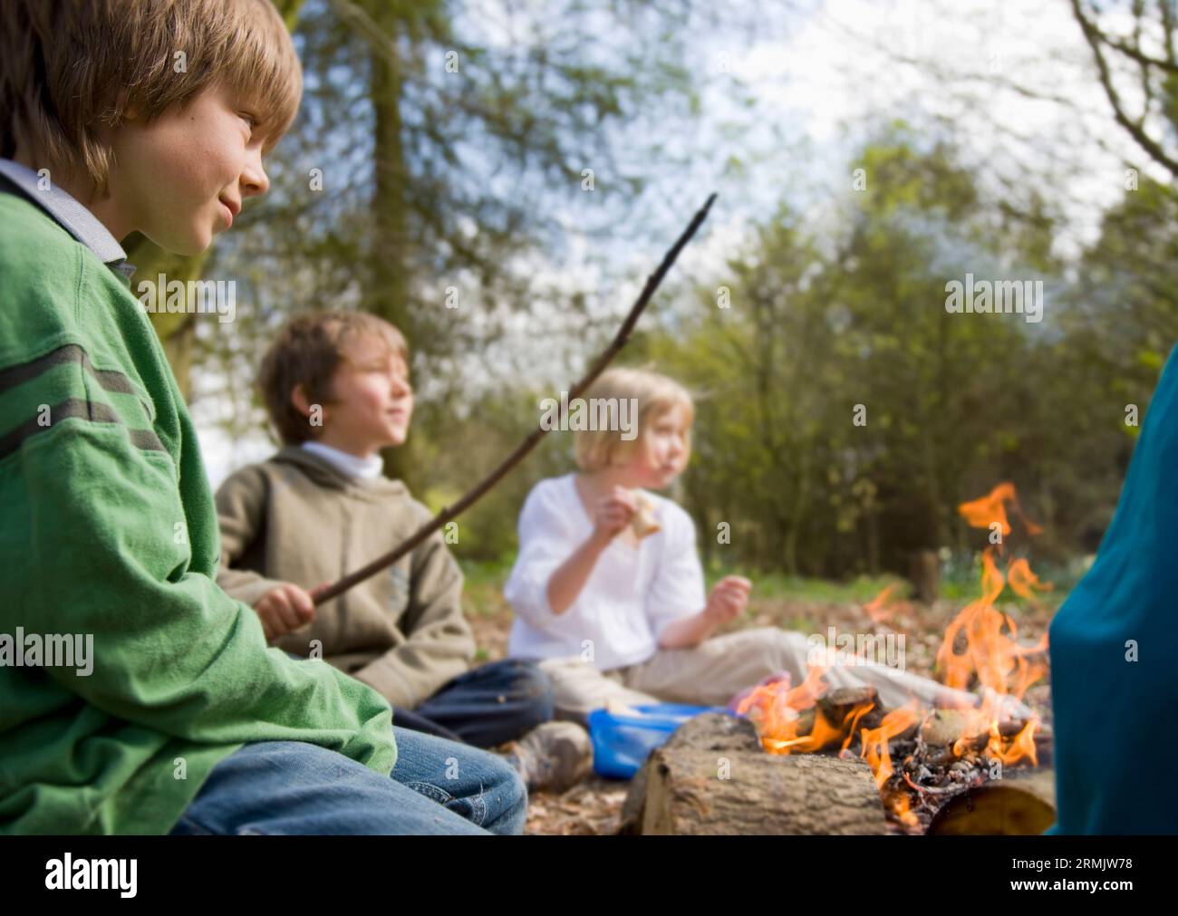 Children sitting around a campfire Stock Photo - Alamy