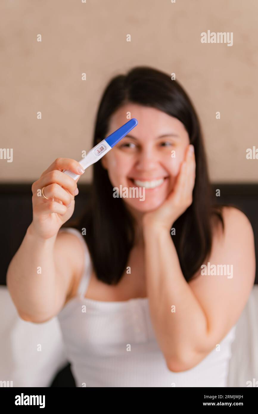 happy woman showing positive pregnancy test Stock Photo - Alamy