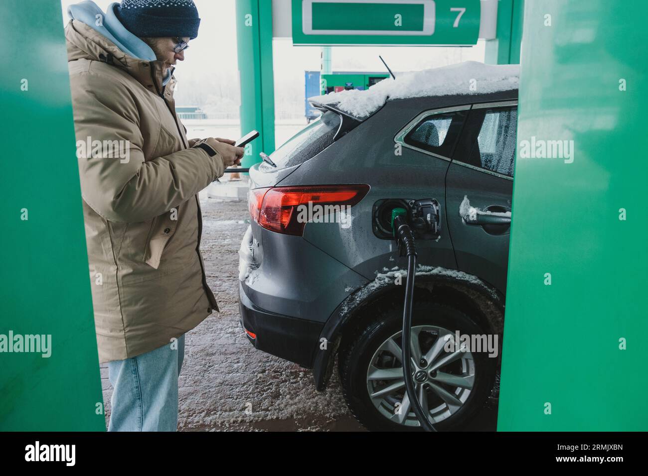 Through an app on his phone, a guy fills up his car and pays for gas ...