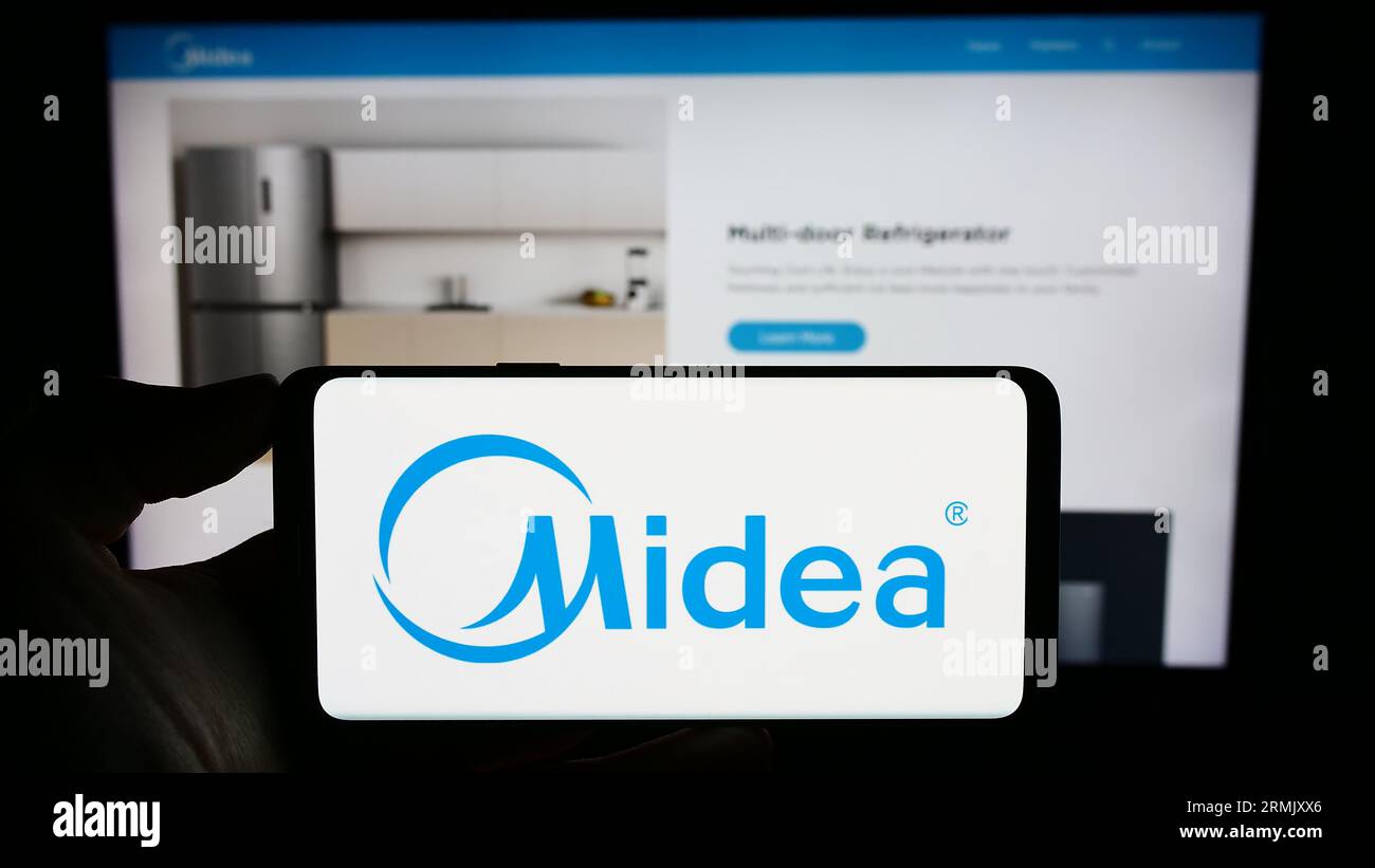 Person holding cellphone with logo of Chinese home appliances company ...