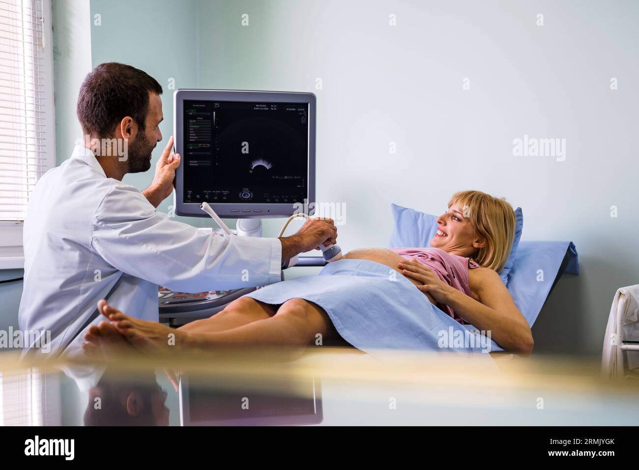 Obstetrician examining pregnant woman belly by ultrasonic scan in ...