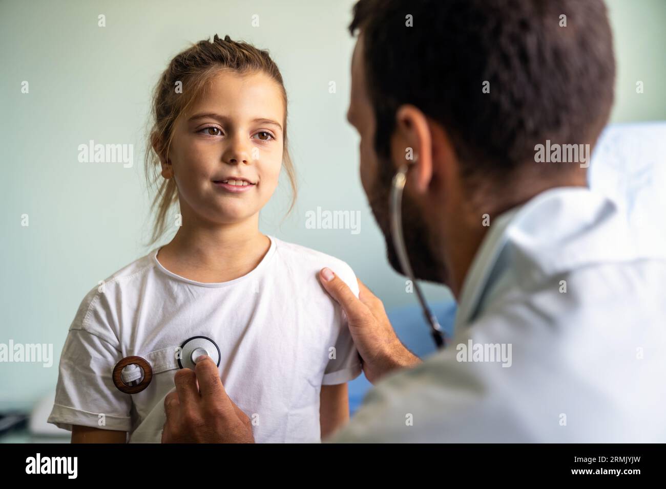 Doctor examines a child with stethoscope in examination room ...