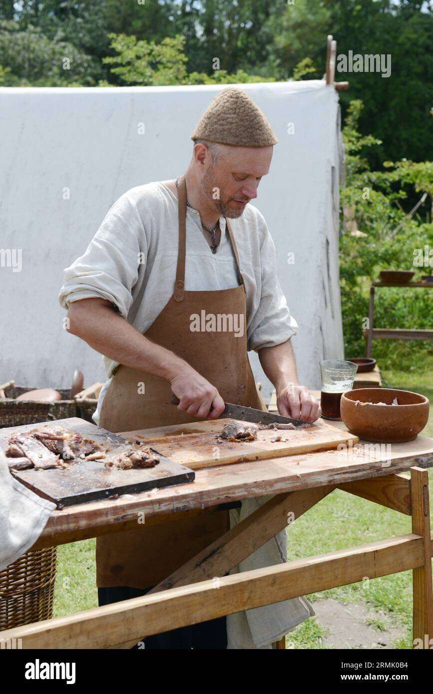 A Danish man chopping roast meat at the Trelleborgs Viking Festival in ...