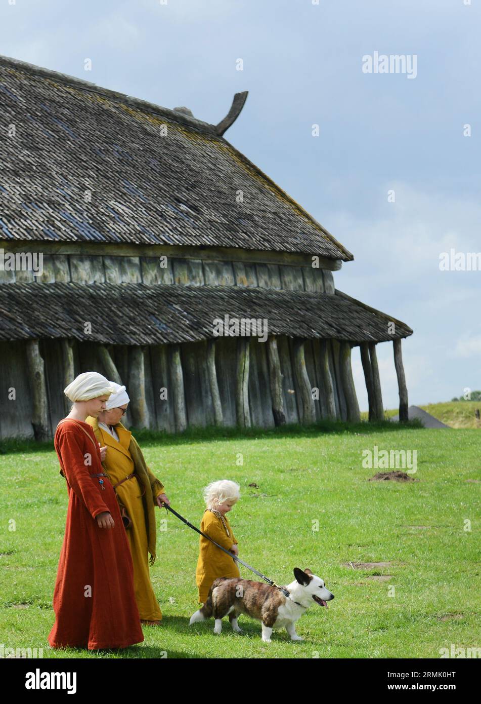 Women and a little girl dressed in traditional Viking clothes walk by ...