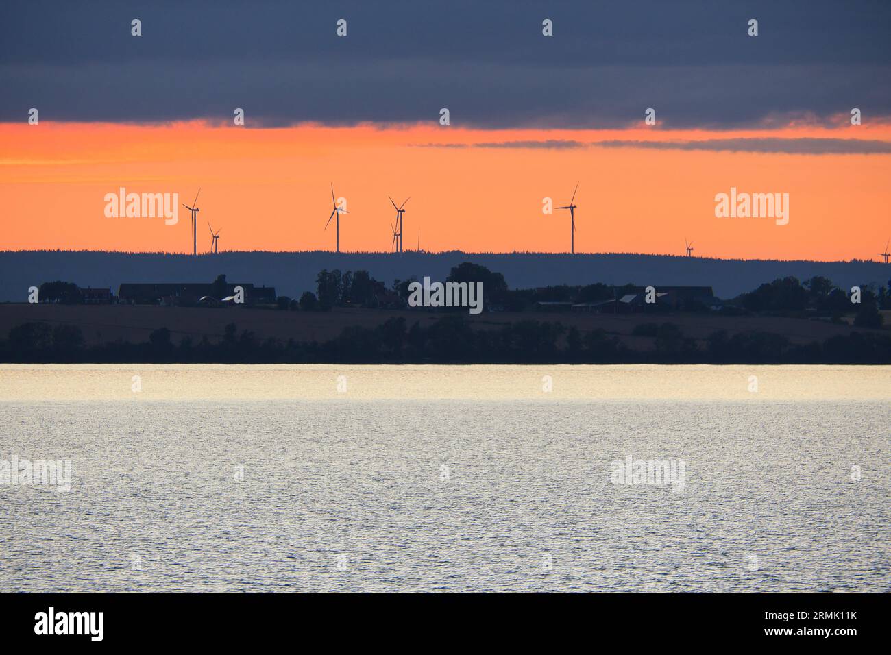 Wind turbine, renewable energy, on a lake at sunset. Clean electricity ...