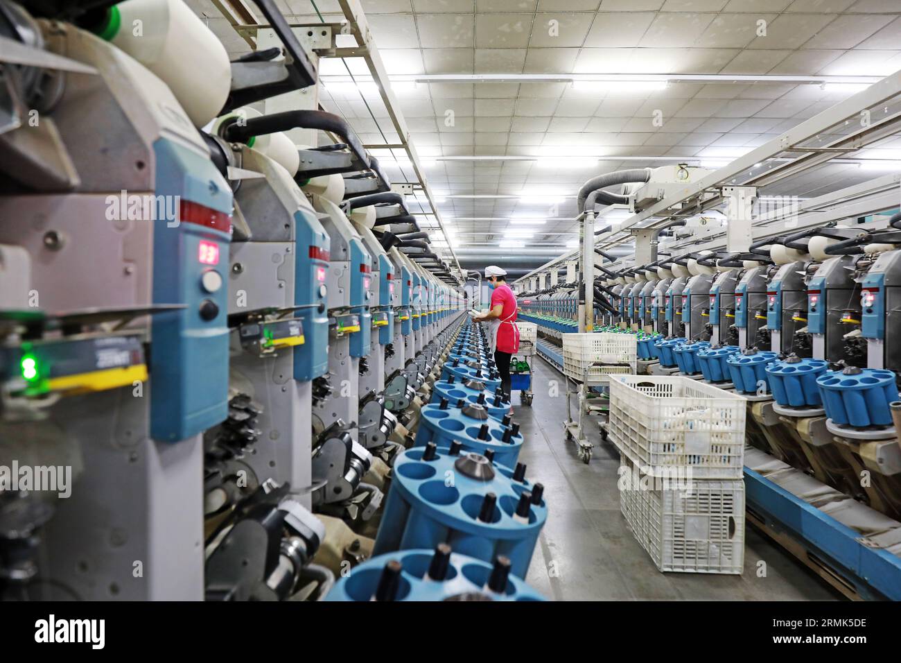 The female worker is busy on the production line in a spinning factory ...