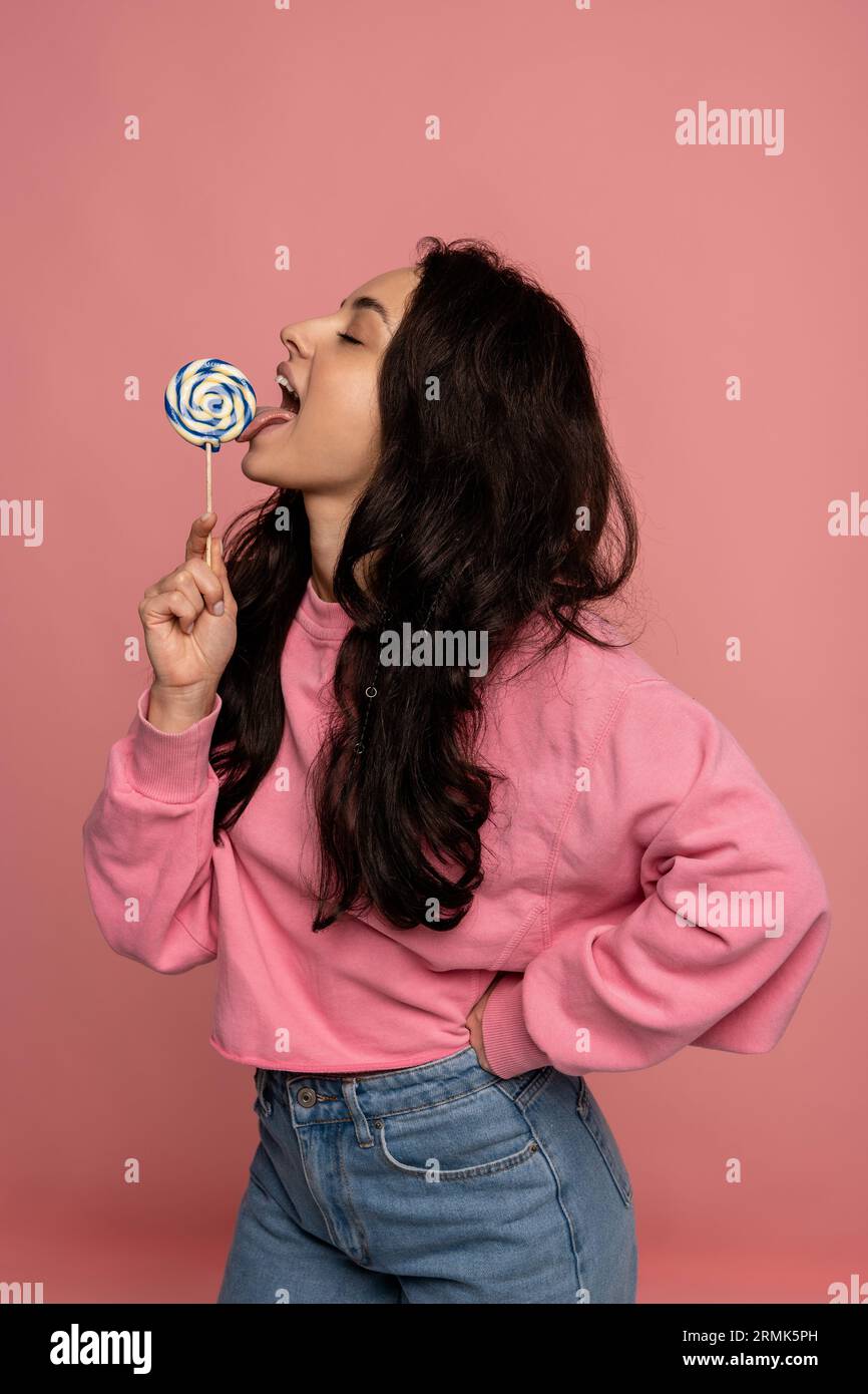 Attractive brunette licking a hard candy with her eyes closed during ...