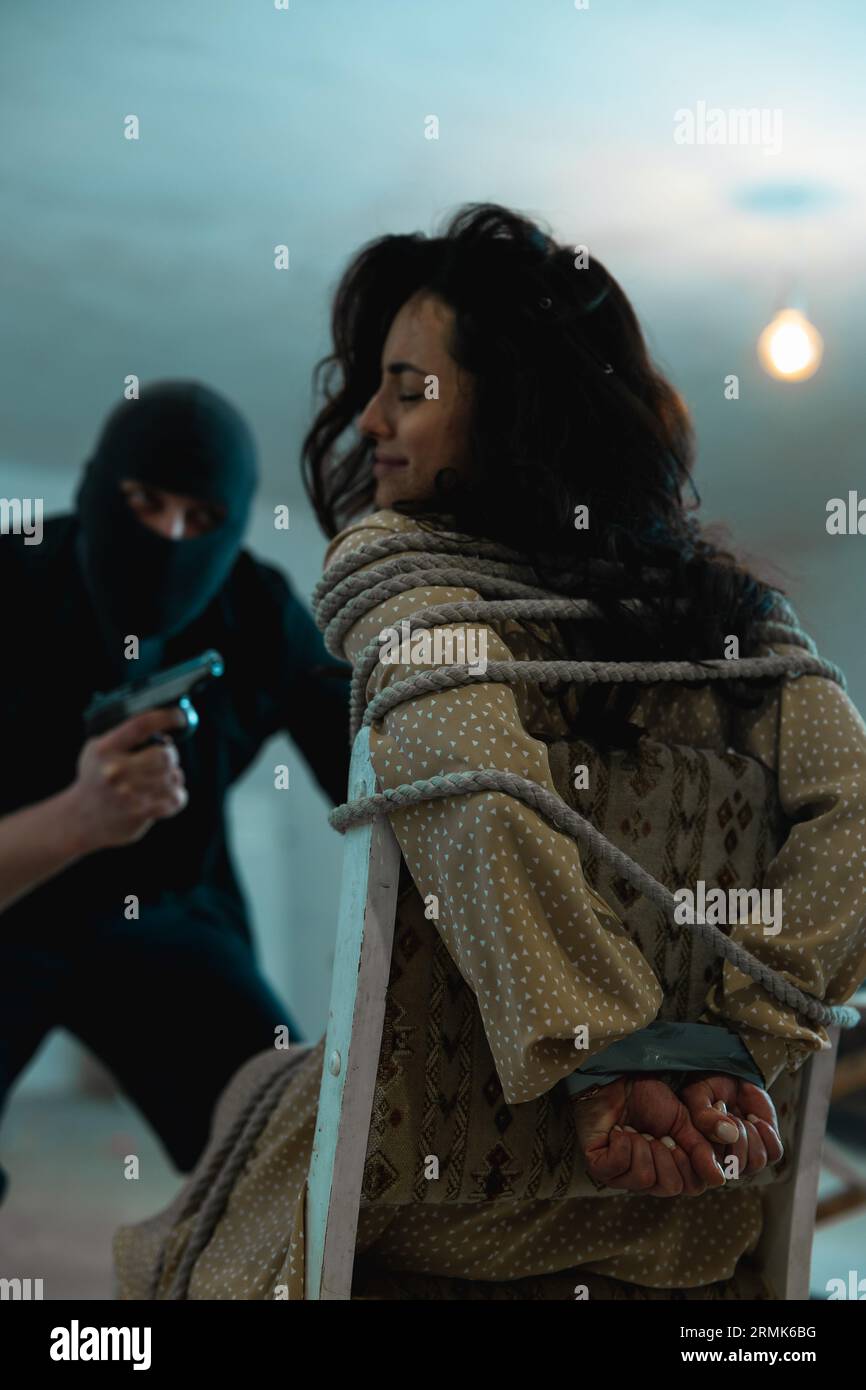 Kidnapper in black clothes threatening with gun for woman tied with ...