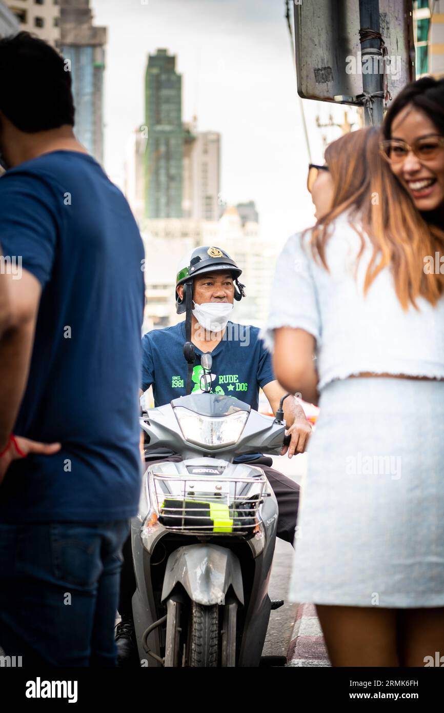 A Thai man pauses on Phetchaburi Rd. Bangkok, Thailand on his motorbike ...