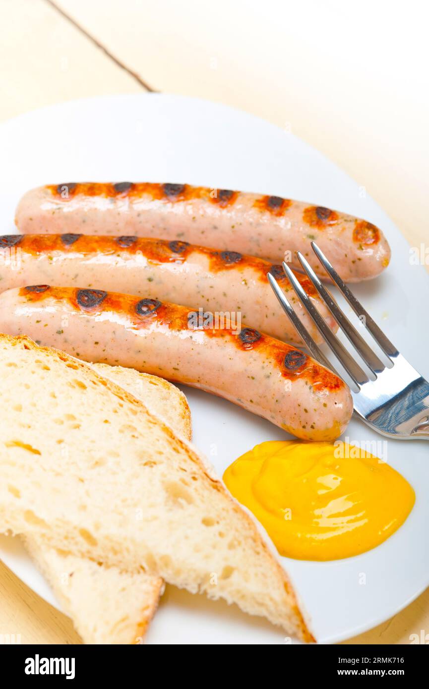 Traditional fresh German wurstel sausages grilled with yellow mustard ...