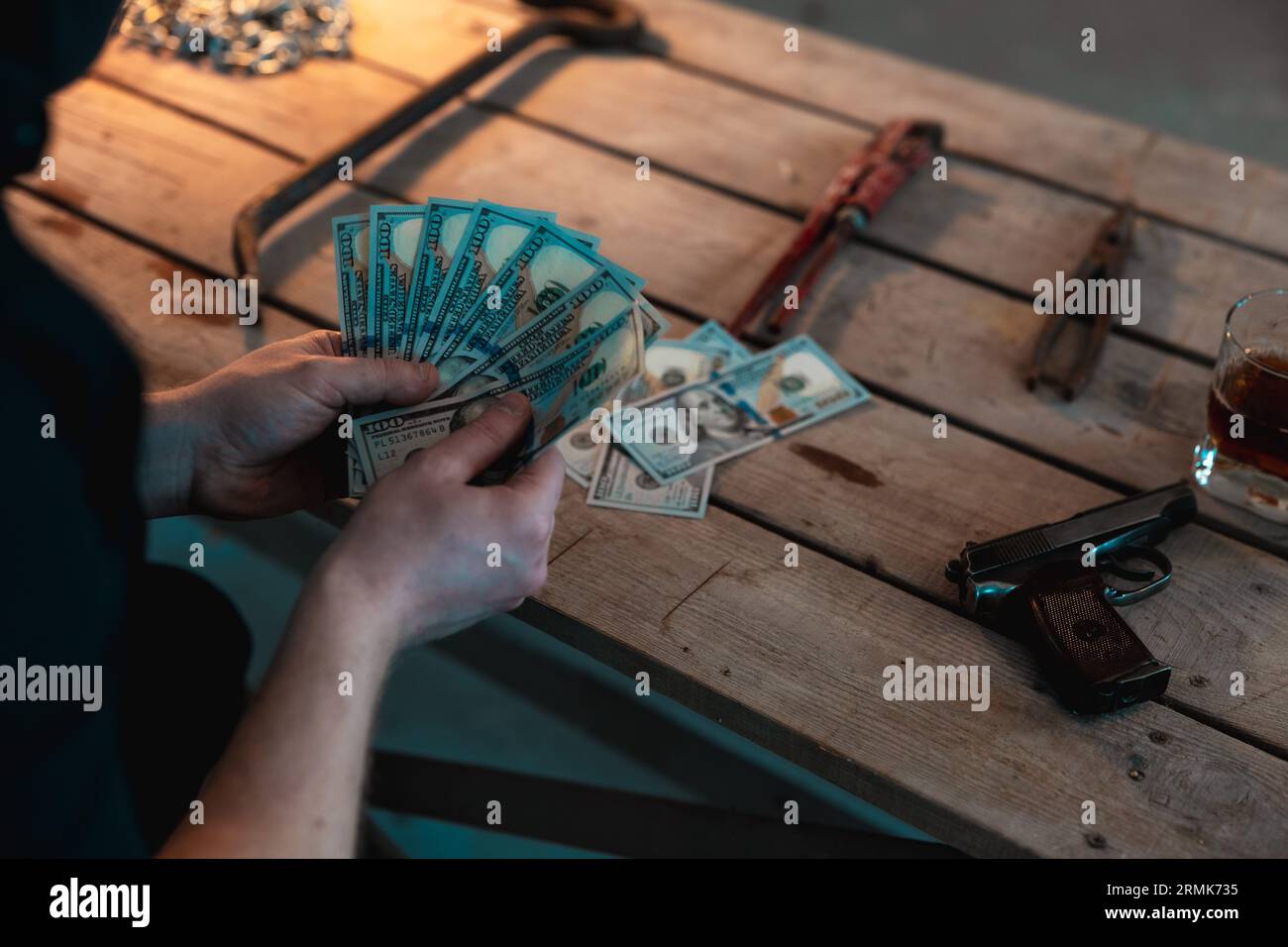 Top view of extortioner holding money, sitting at the table in the ...