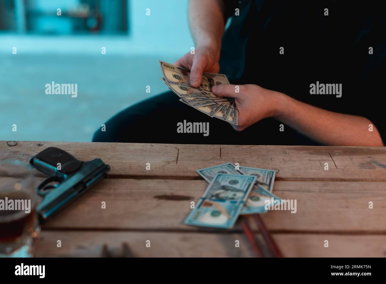 Cropped photo of man in a black clothes counting money in the basement ...