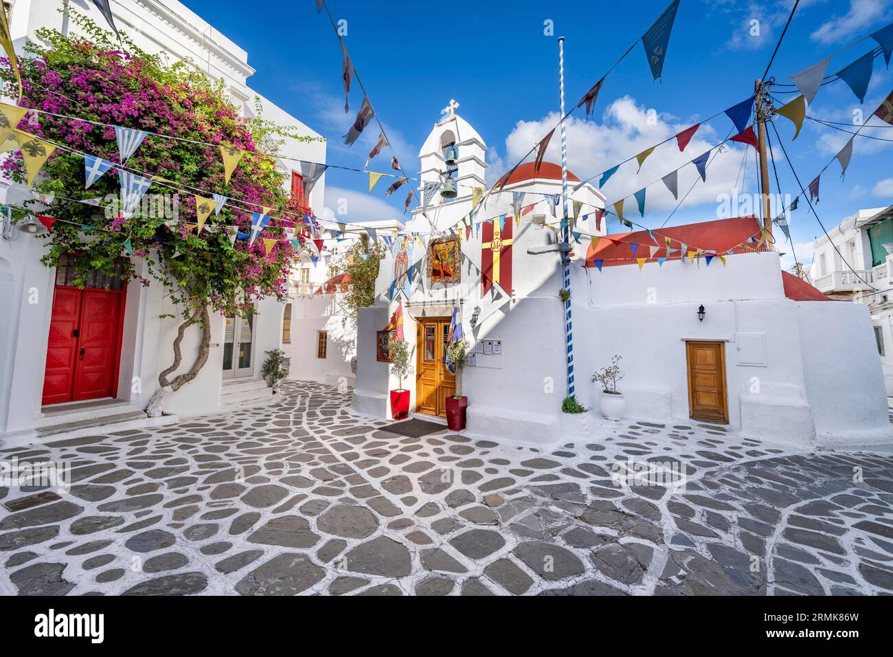 Cycladic Greek Orthodox Church decorated with flags, alleys of the old ...