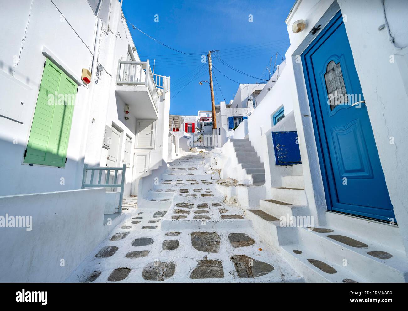 Cycladic white houses with colourful shutters and doors, alleys of the ...