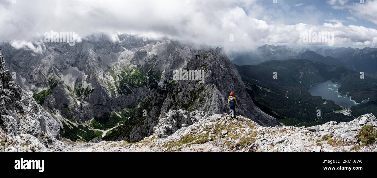 Panorama, mountaineer at the summit of the Waxenstein, view over rocky ...