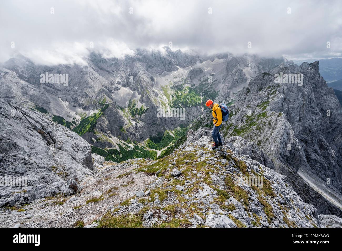 Mountaineer at the summit of the Waxenstein, view over rocky and narrow ...