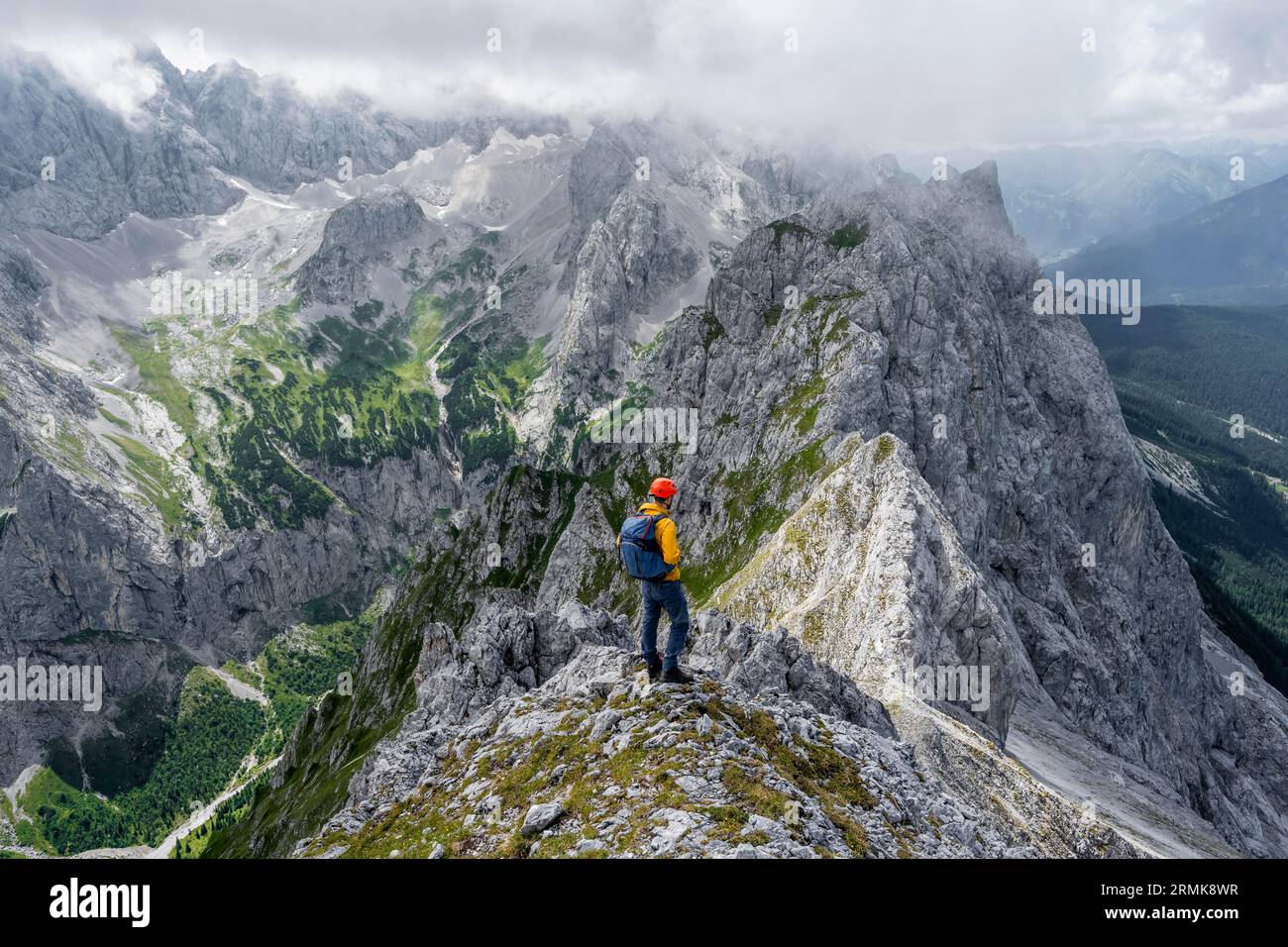 Mountaineer at the summit of the Waxenstein, view over rocky and narrow ...
