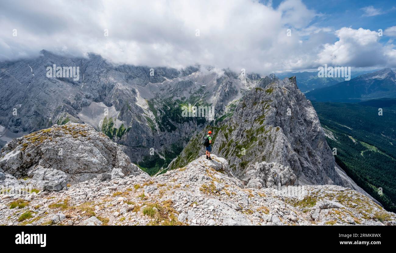 Mountaineer at the summit of the Waxenstein, view over rocky and narrow ...