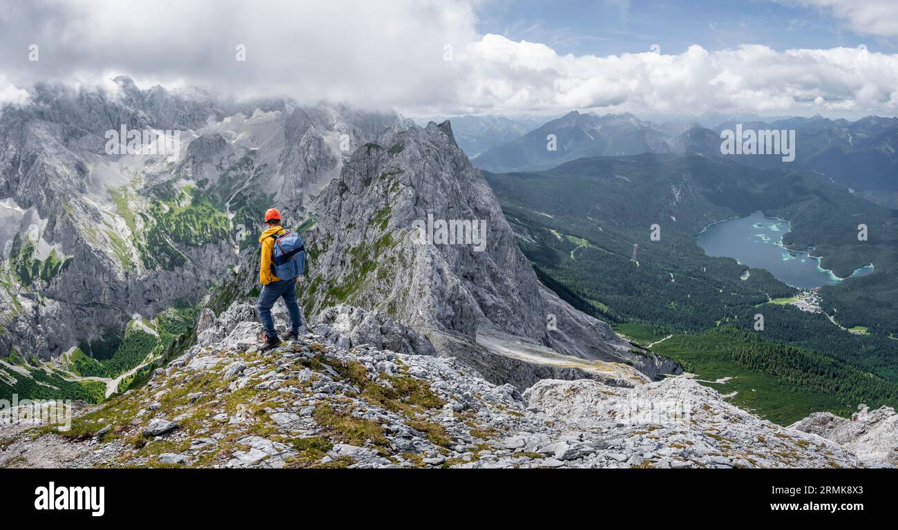 Mountaineer at the summit of the Waxenstein, view over rocky and narrow ...