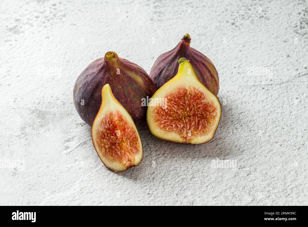View of whole and cut organic figs on stone table Stock Photo - Alamy
