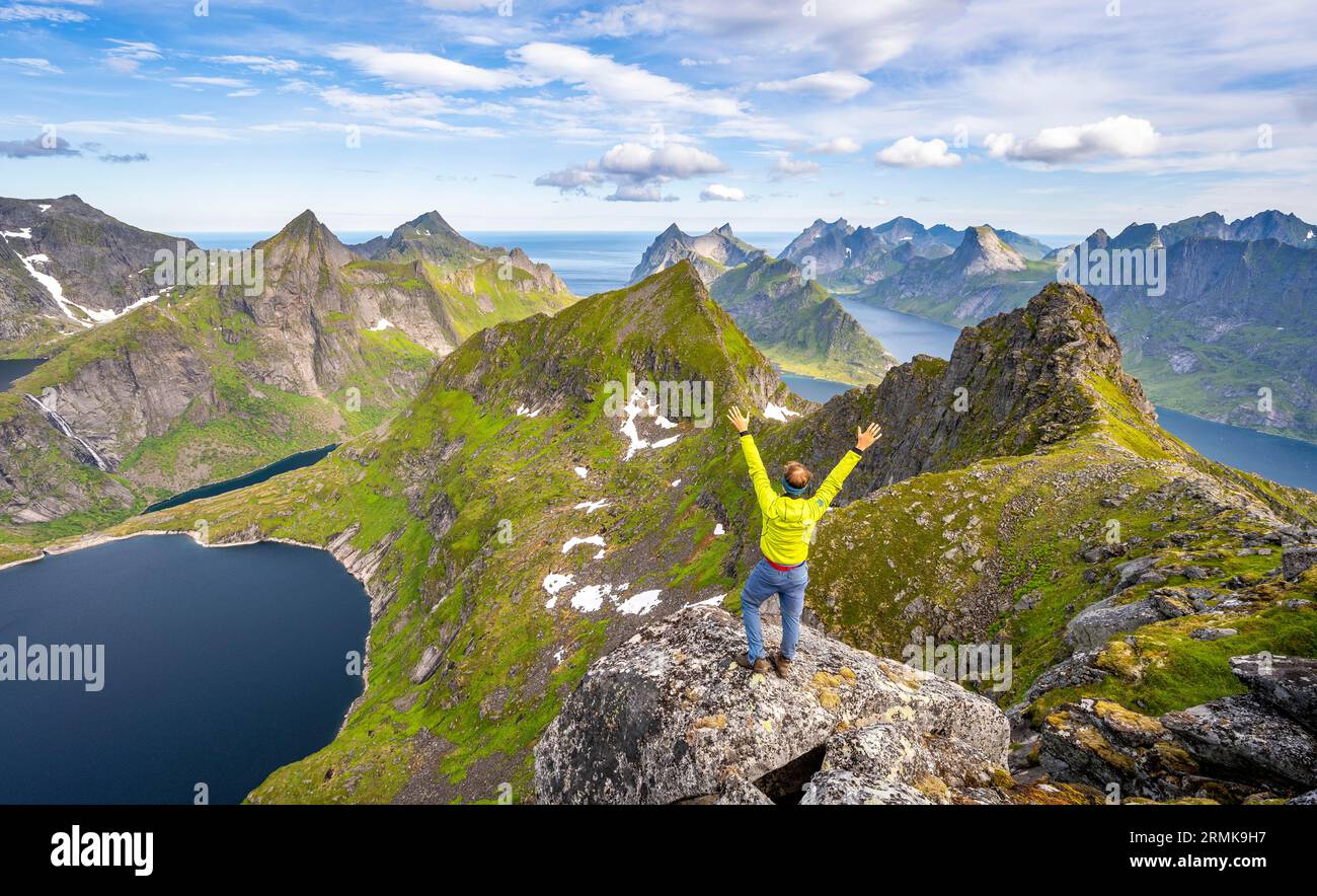 Mountaineer stretching his arms in the air, at the summit of Munken ...