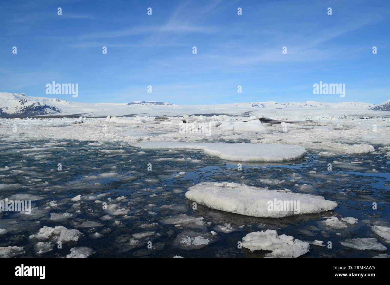 Frozen icey landscape with floating icebergs under blue skies in ...