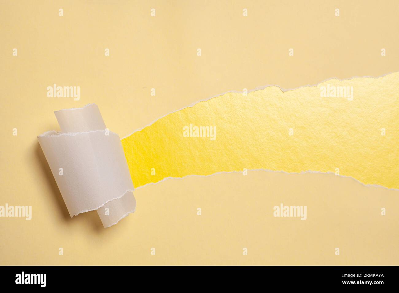 Torn paper with opening showing yellow background Stock Photo - Alamy