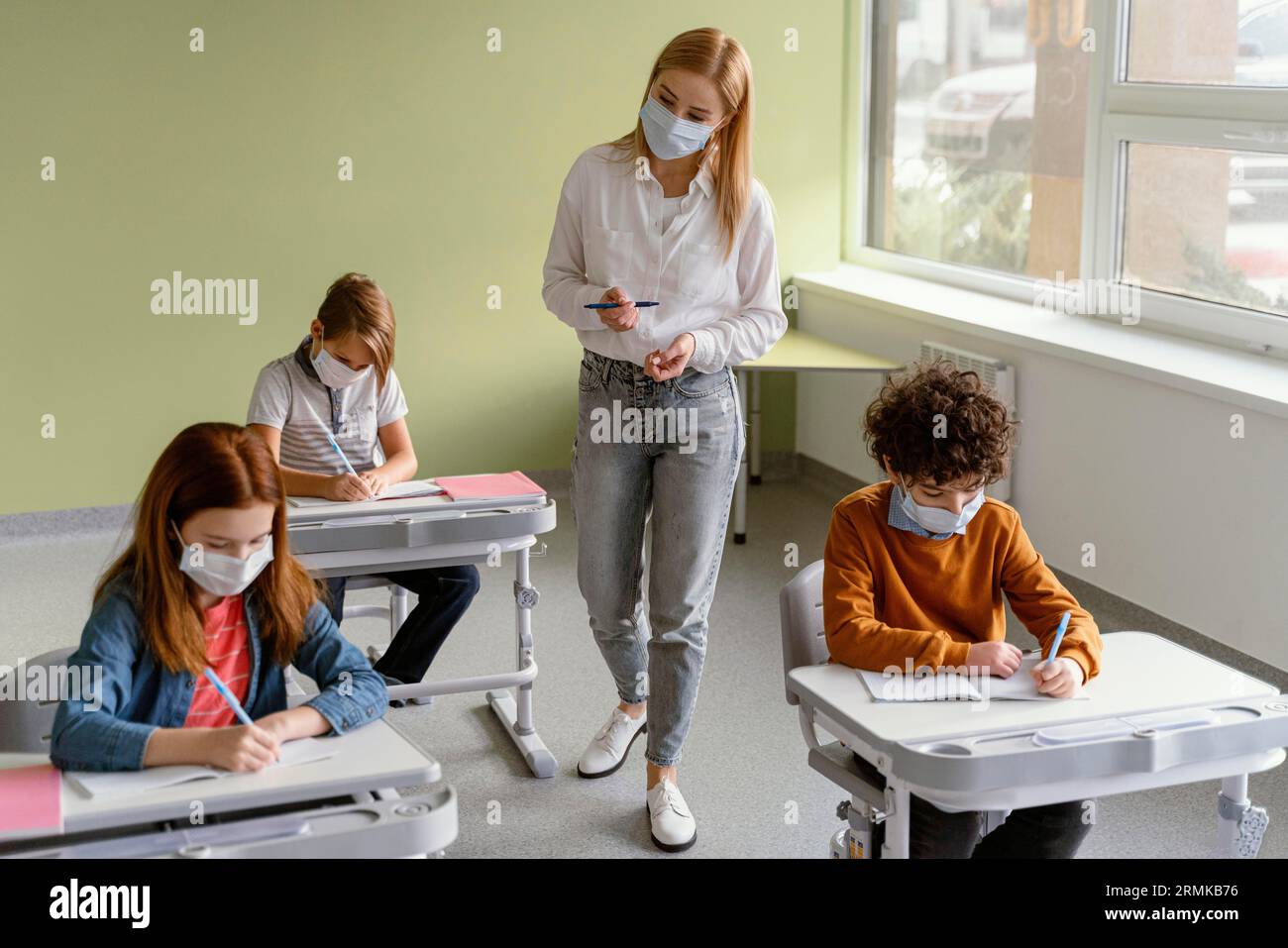 Children with medical masks learning school with teacher Stock Photo ...