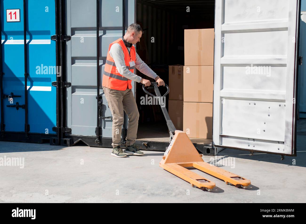 Full shot man carrying pallet truck Stock Photo - Alamy