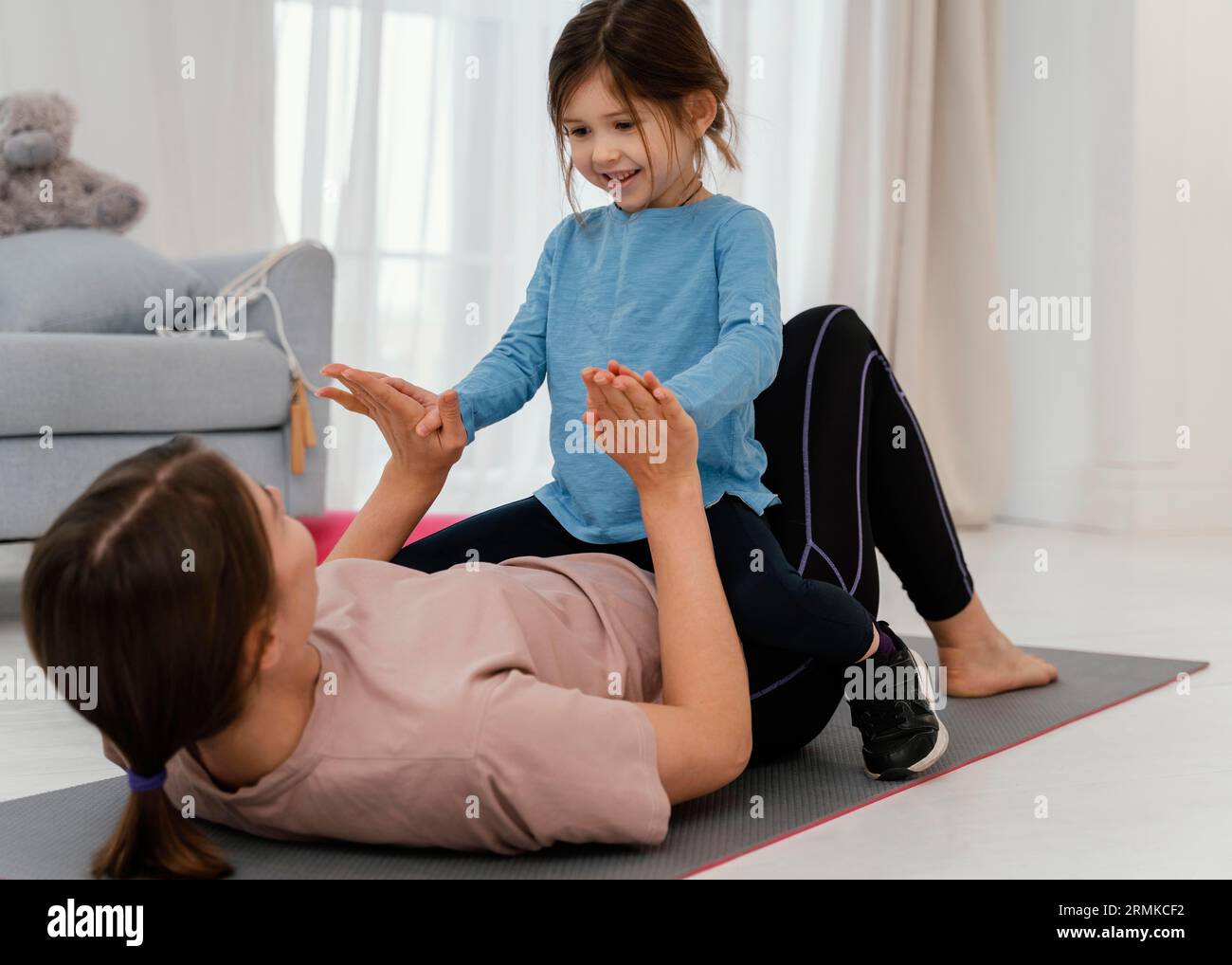 Mother training with smiley child Stock Photo - Alamy