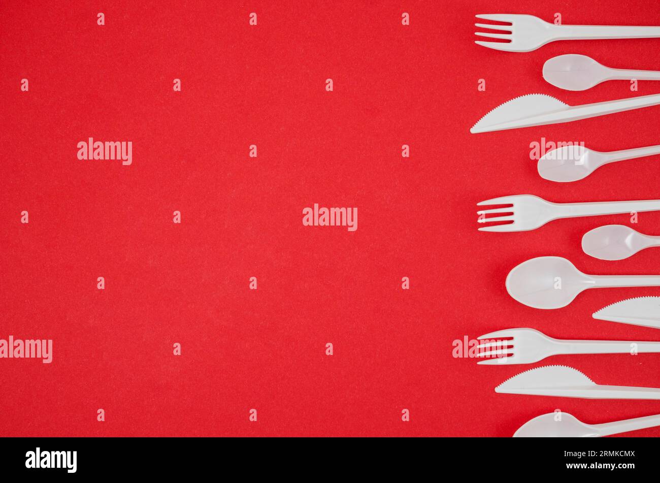 Plastic spoon fork arranged row bright red backdrop Stock Photo - Alamy